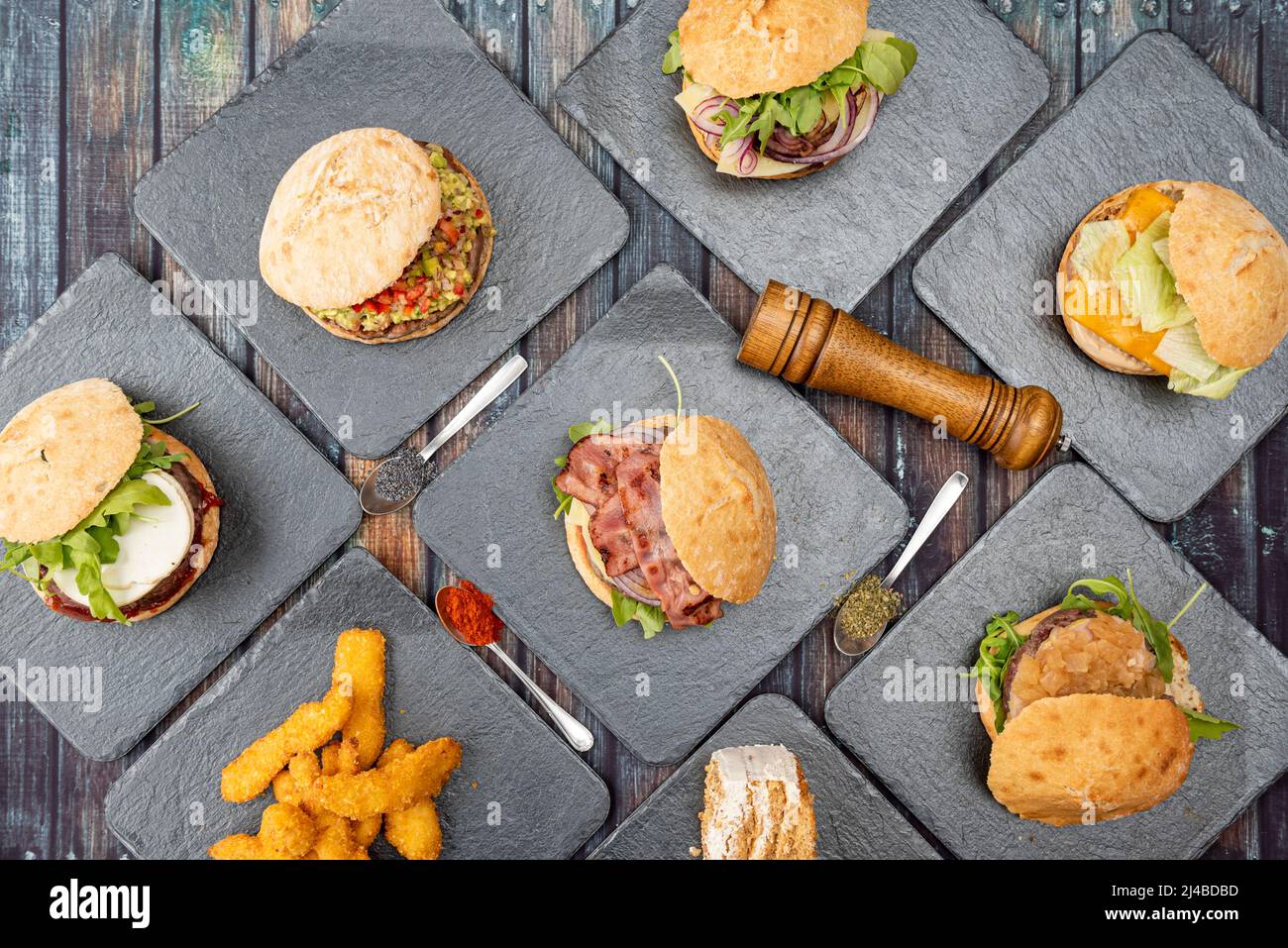 Set of slate plates with muffin burgers, goat cheese, fried bacon, red ...