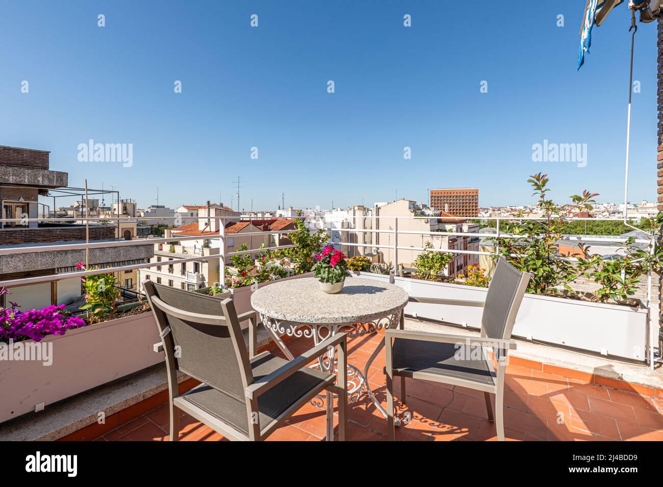 Nice terrace in a penthouse apartment with lots of flowers, a round ...