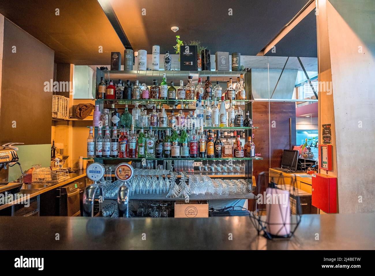 Variety of alcohol in glass bottles on racks at bar counter in luxury ...