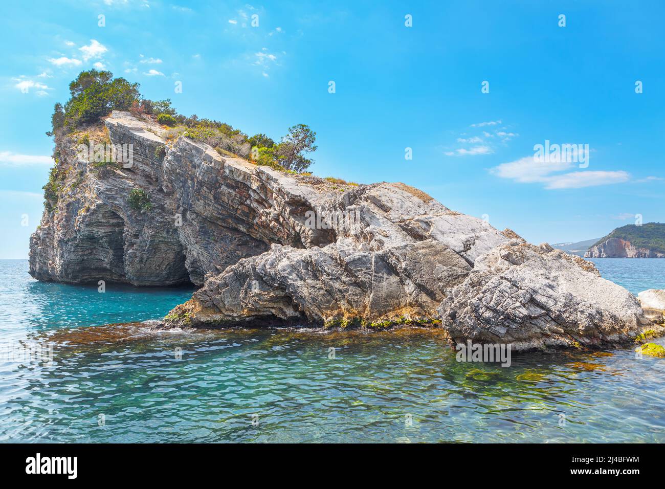 Rocky Islet in the sea water . Halfmoon Beach in Budva Montenegro Stock ...