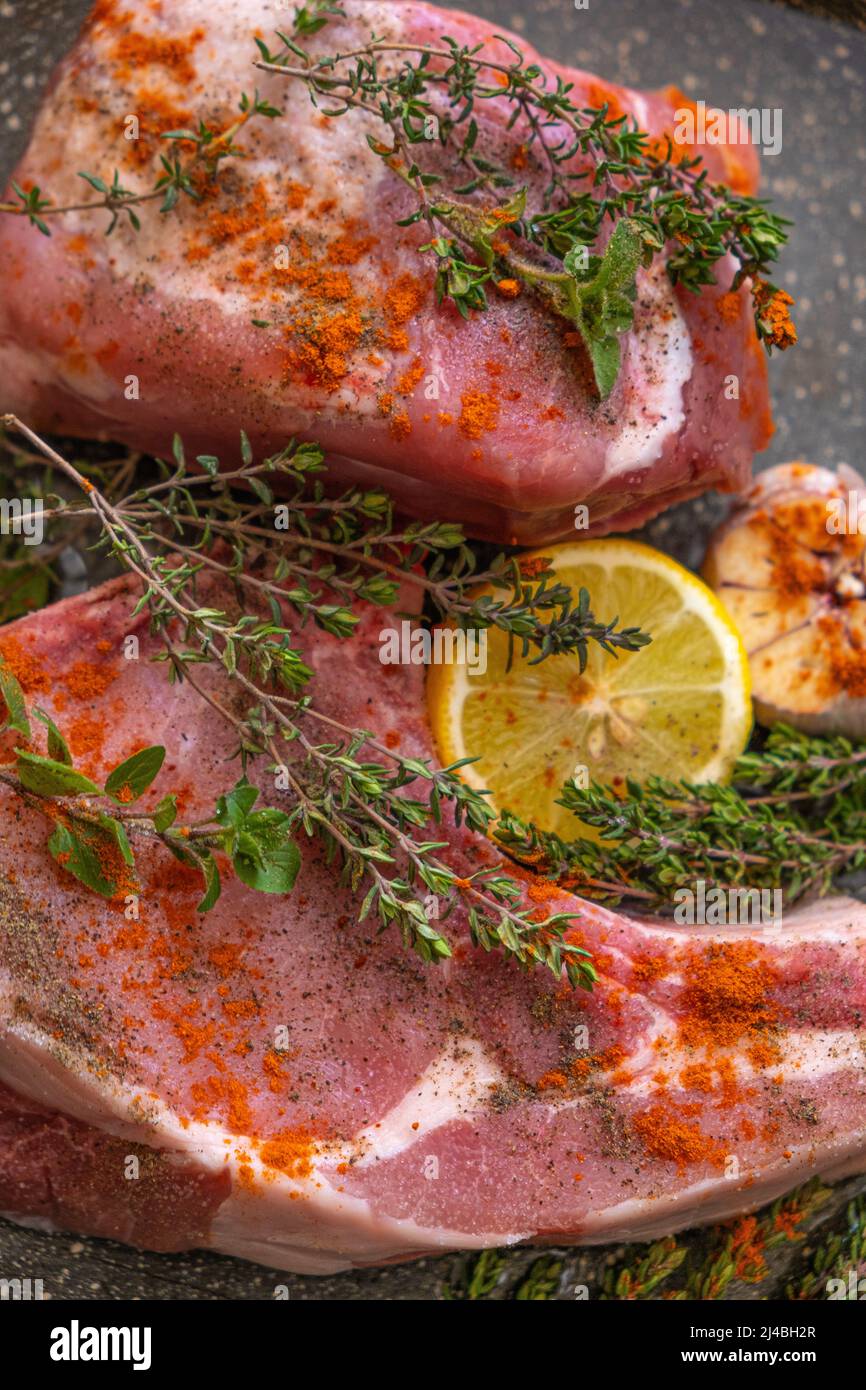 Pork meat with herbs and spices. Raw meat chunks, oregano, thyme, red ...