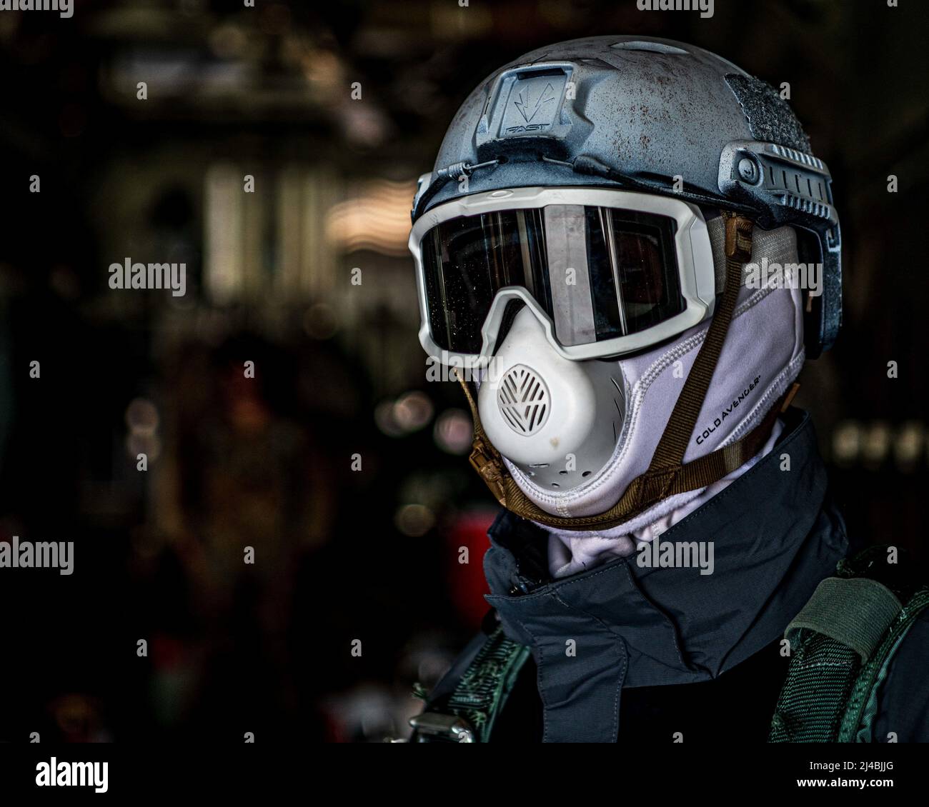 A Naval Special Warfare jump master performs in-flight duties during a ...