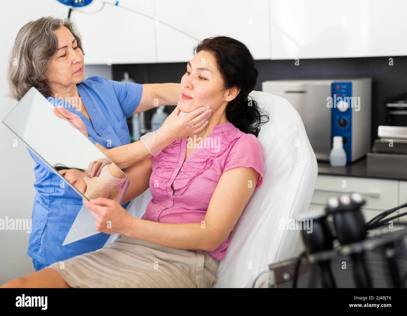Cosmetician explaining future treatment to female patient Stock Photo ...