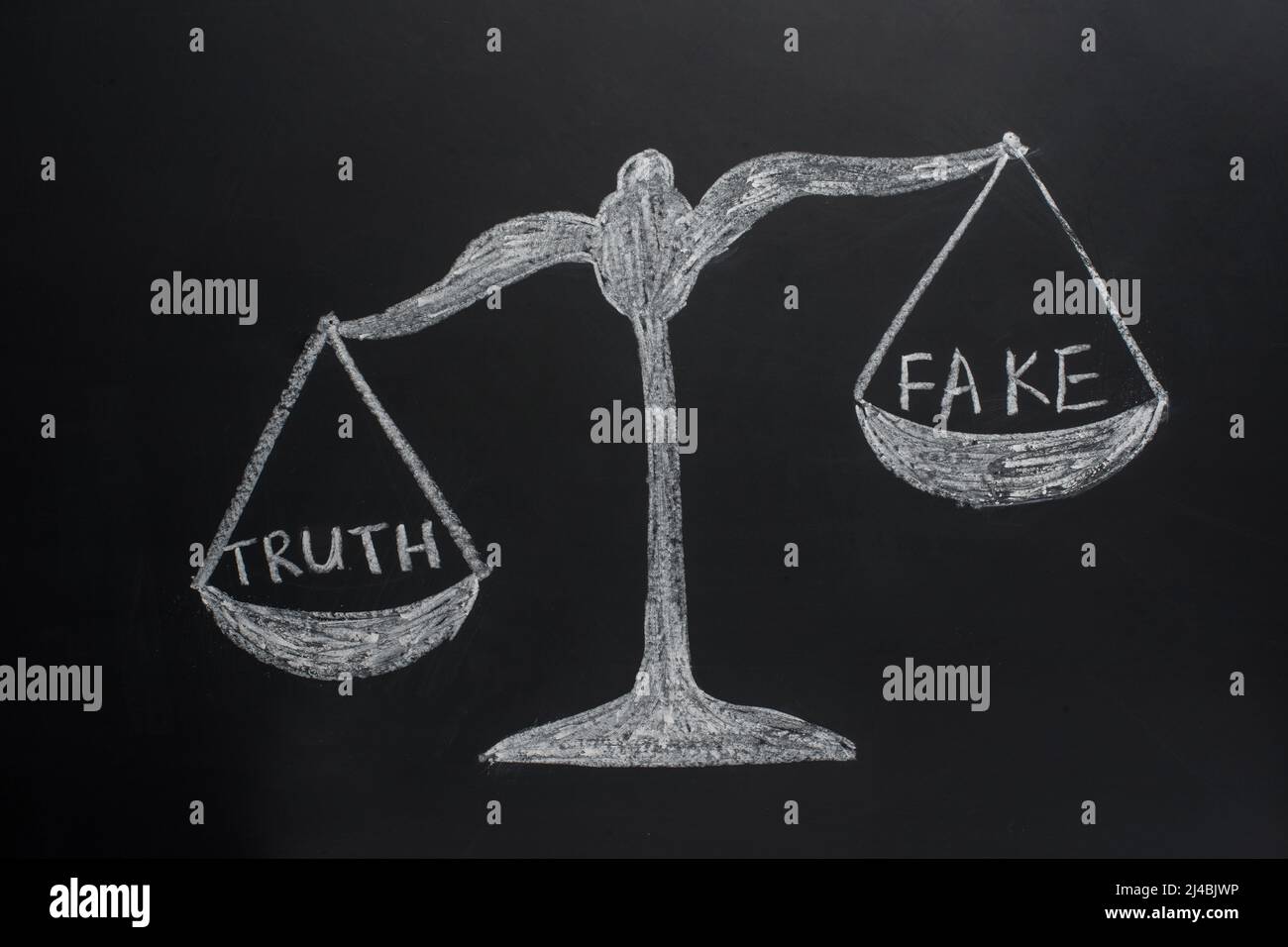 Scales with truth and fake. The concept on the blackboard Stock Photo ...