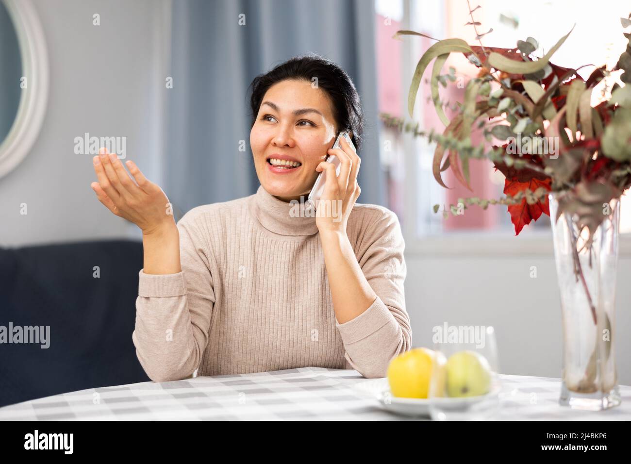 Positive asian woman communicates with someone on mobile phone Stock ...