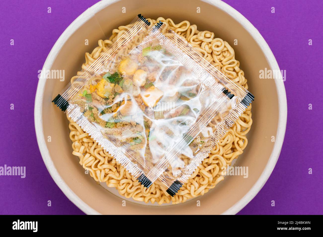 Opened Package with Uncooked Instant Noodles on Violet Background. Raw ...