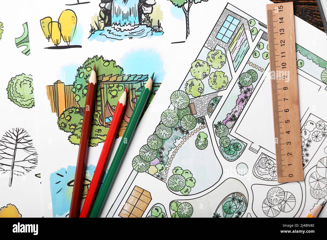 Paper sheets with sketches for landscape design and stationery on table ...