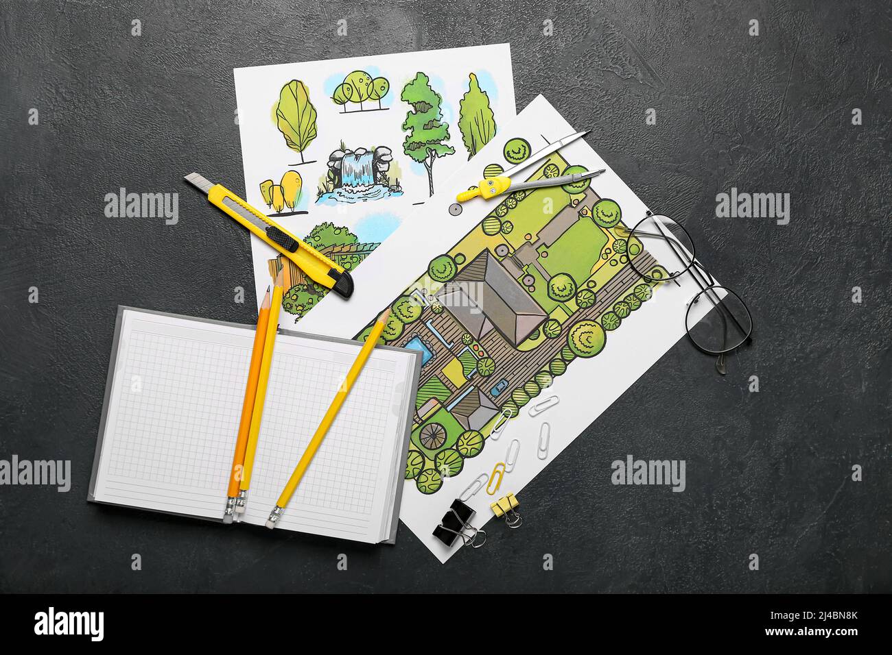 Paper sheets with sketches for landscape design and stationery on dark ...