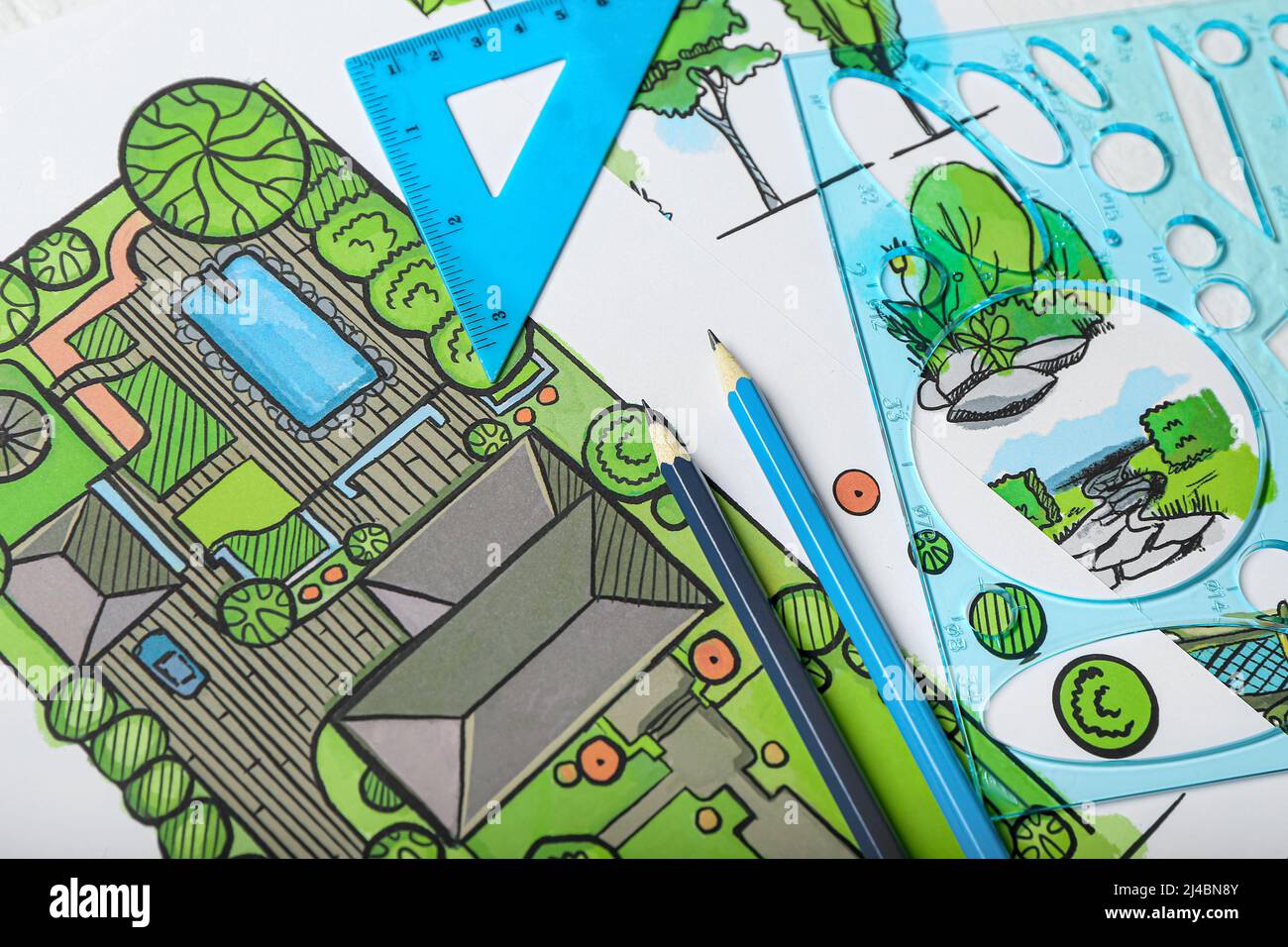 Paper sheets with sketches for landscape design and stationery on table ...