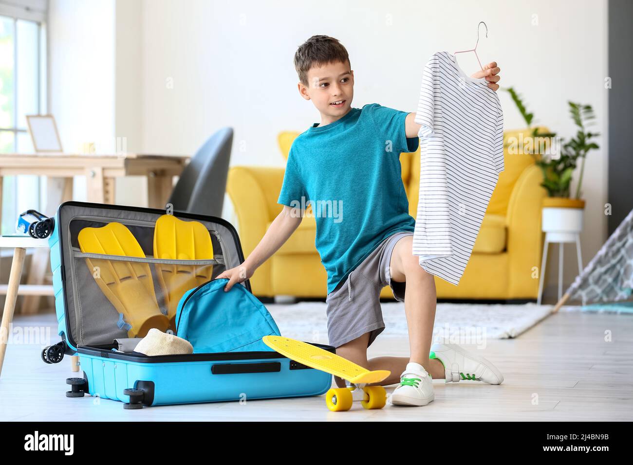Boy packing suitcase hi-res stock photography and images - Alamy