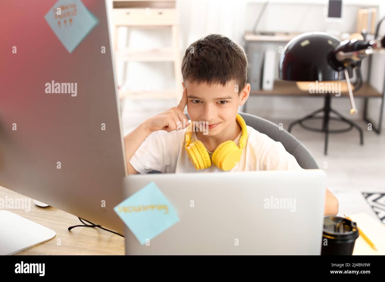 Cute little programmer using modern computer at home Stock Photo - Alamy
