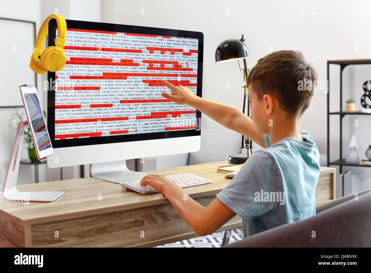 Cute little programmer pointing at computer monitor at home Stock Photo ...