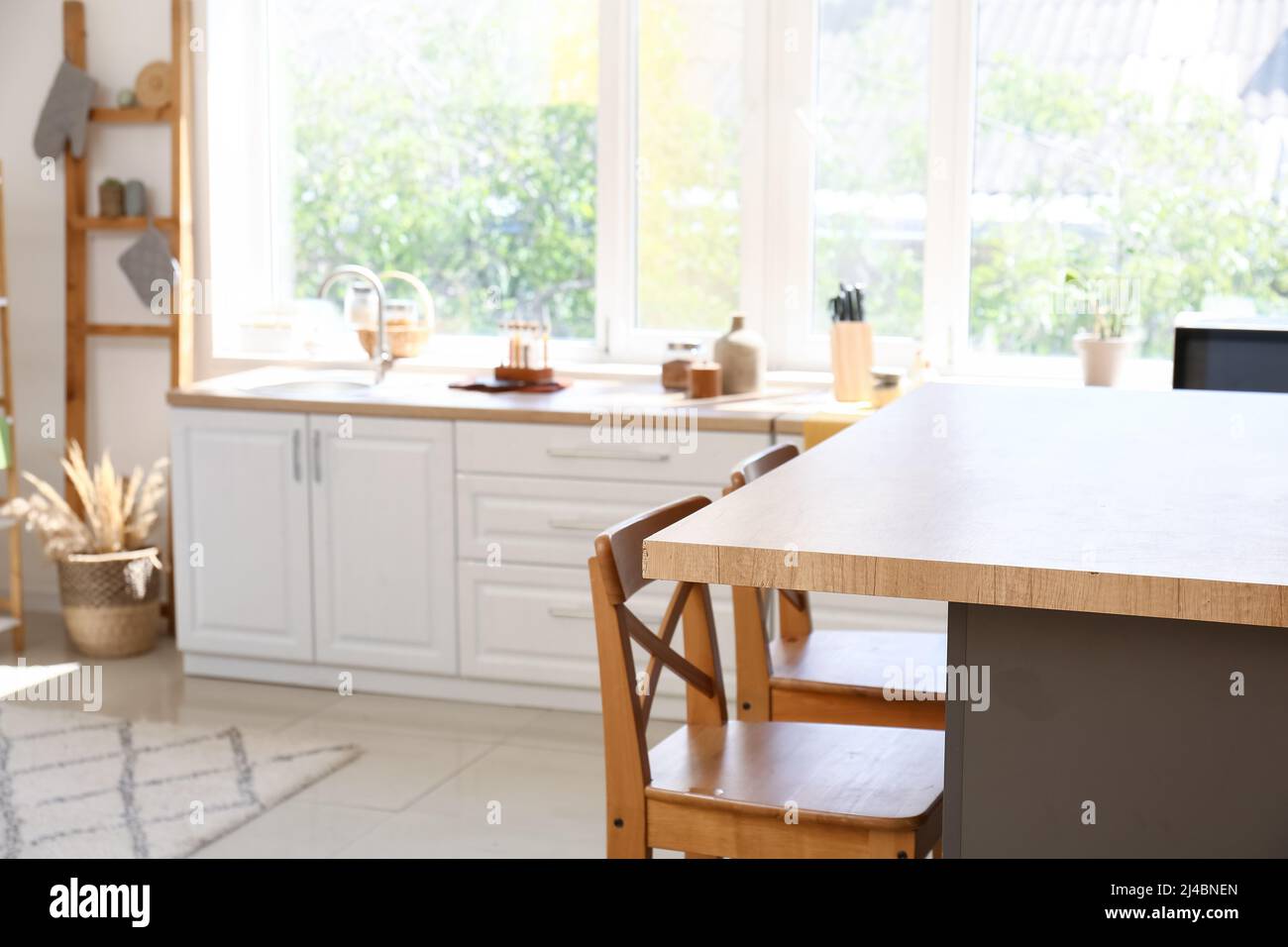 Wooden counter with chairs in modern interior of kitchen Stock Photo ...