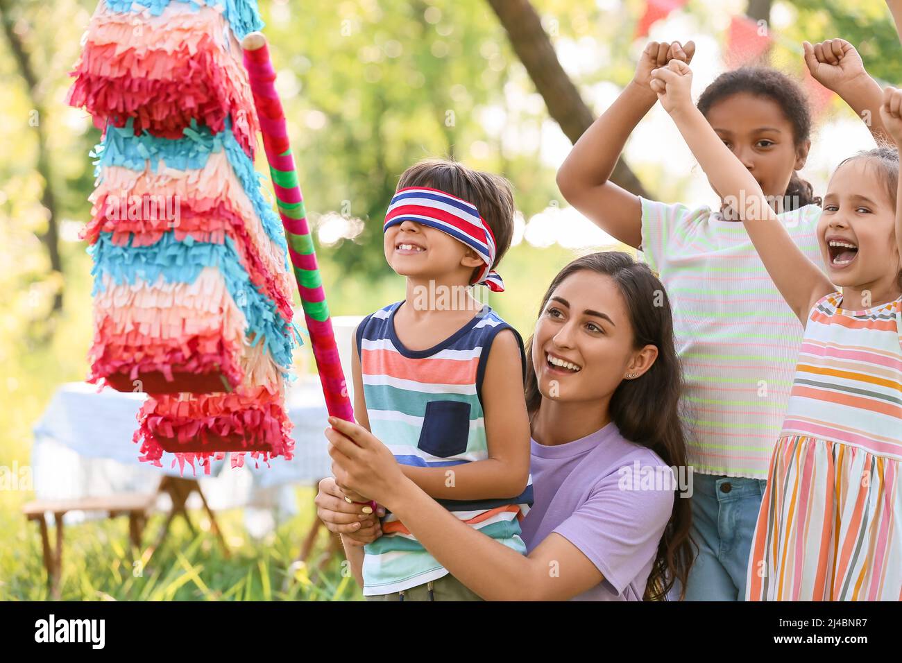 Woman and cute children at pinata birthday party Stock Photo - Alamy