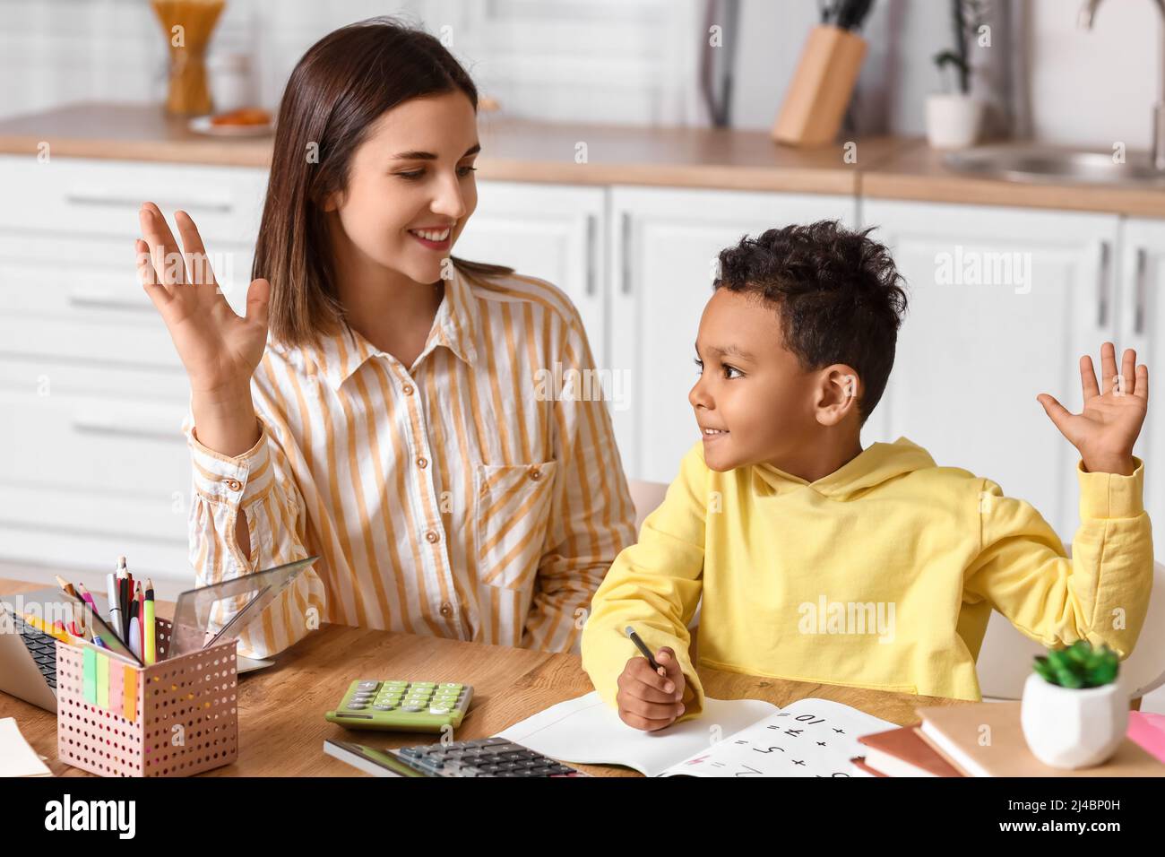Little African-American boy giving high-five to his tutor at home Stock ...