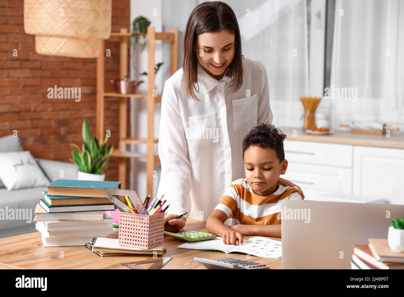 Little African-American boy studying Mathematics with tutor at home ...