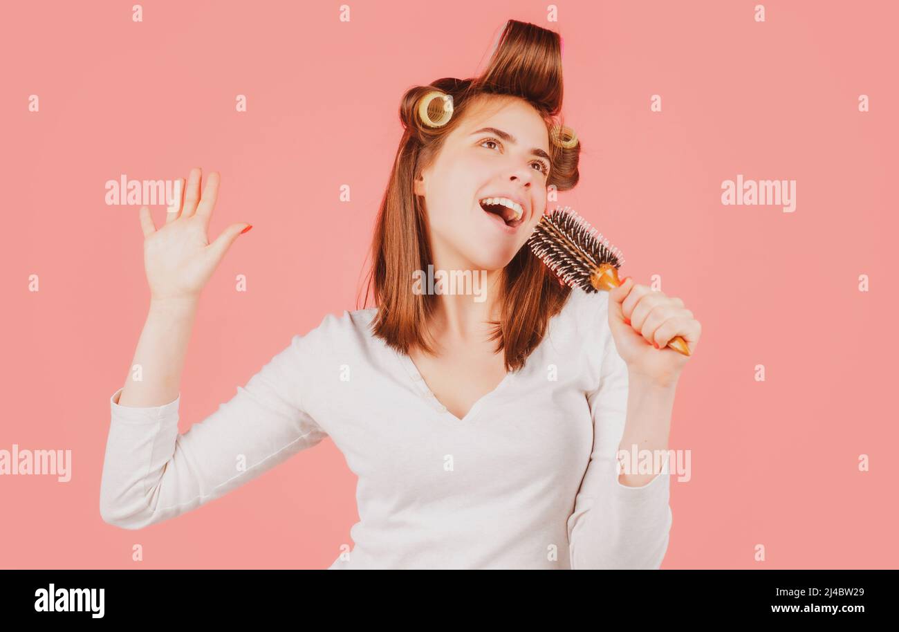 Funny woman singing with comb. Girl combing hair. Beautiful young woman ...