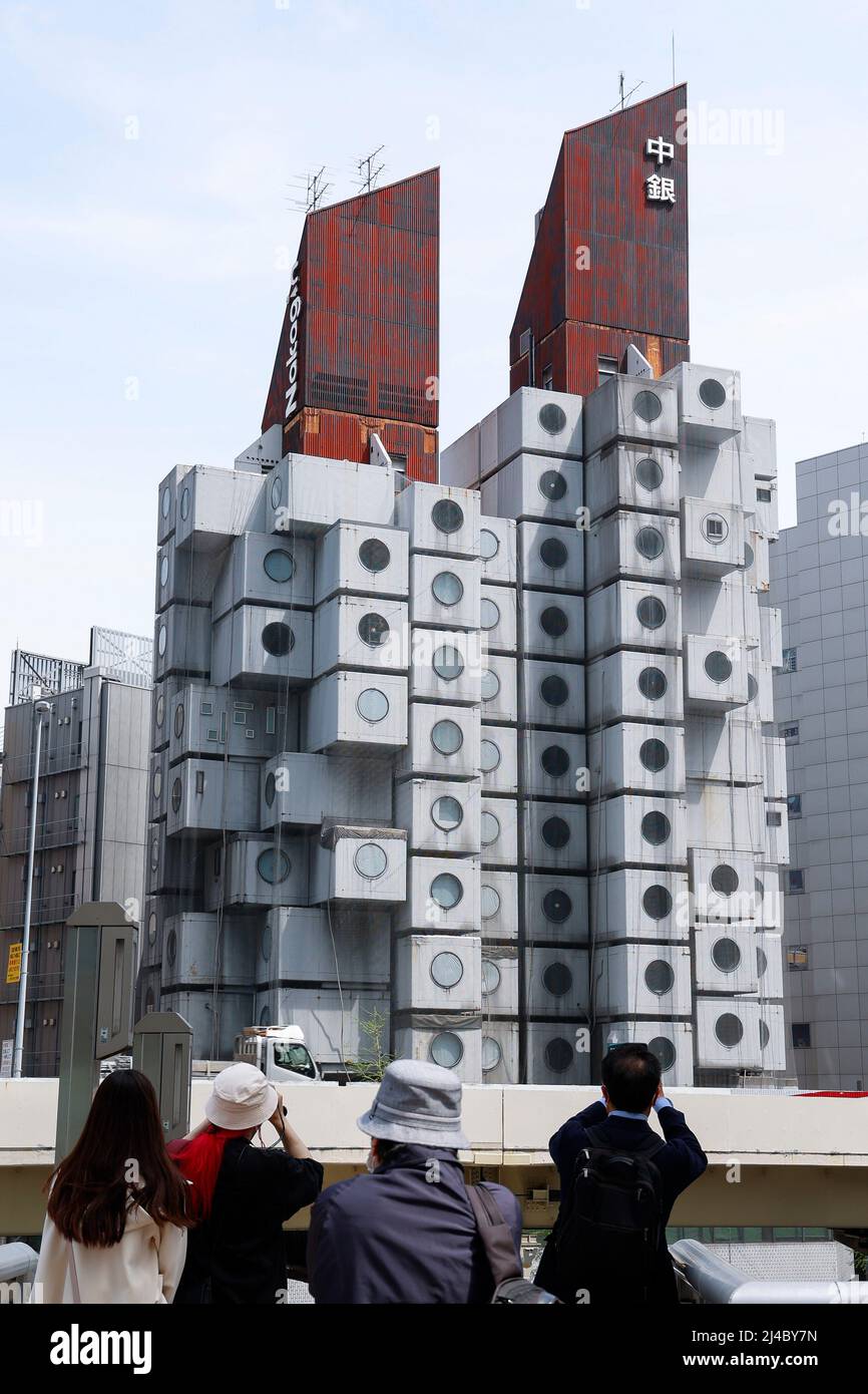 Tokyo, Japan. 13th Apr, 2022. People take photos of the Nakagin Capsule Tower under demolition ...