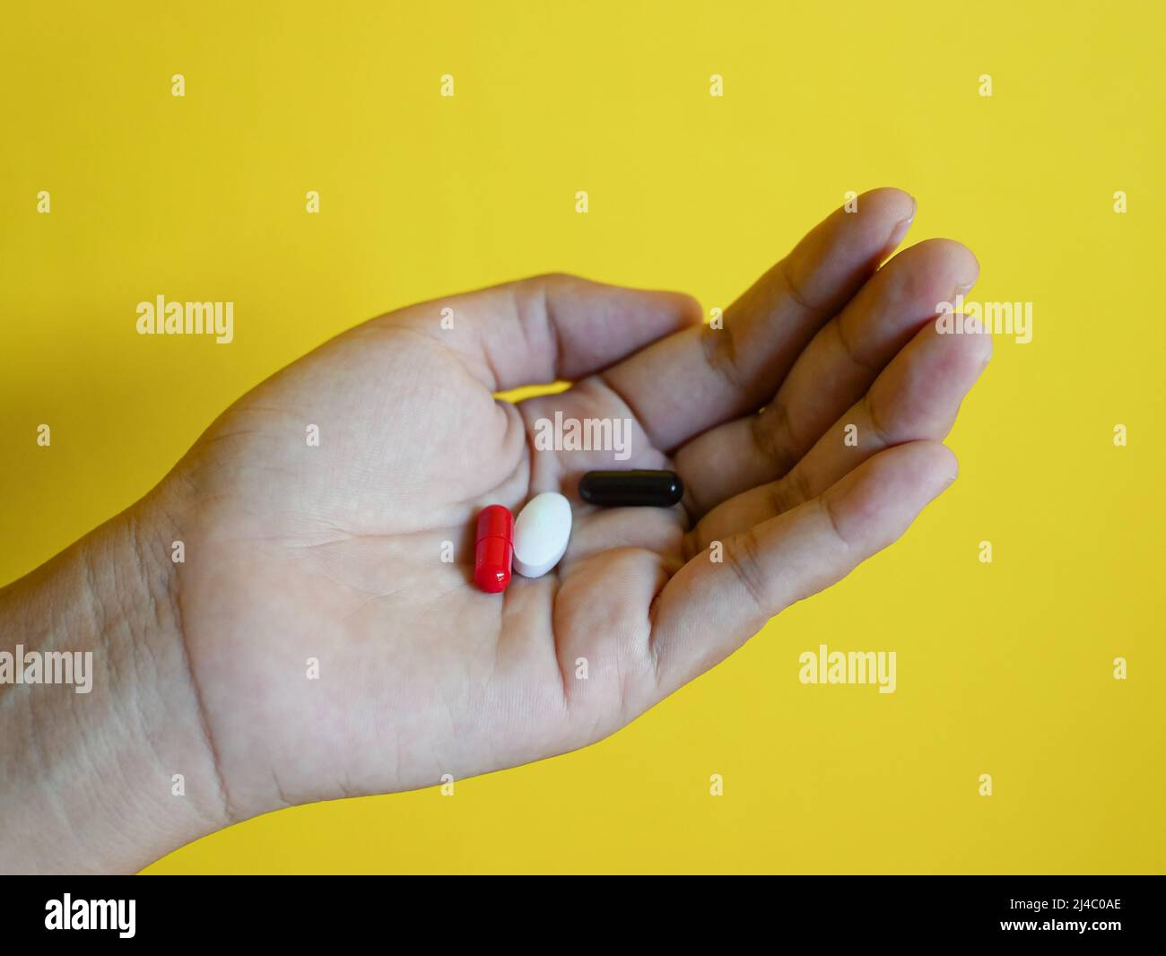 Hand holding vitamin tablets hi-res stock photography and images - Alamy