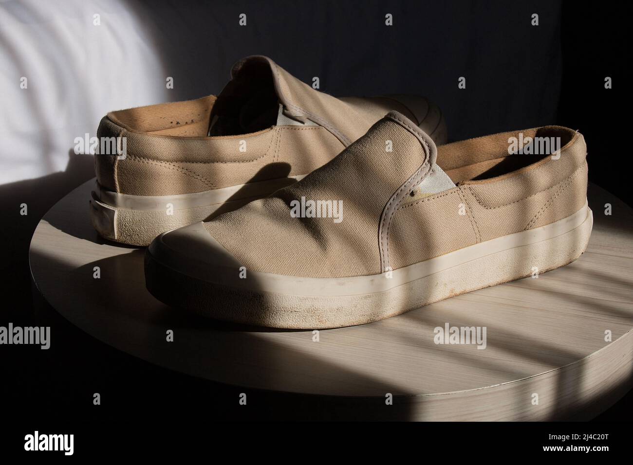 a pair of cream-colored shoes, kept on a round table Stock Photo - Alamy