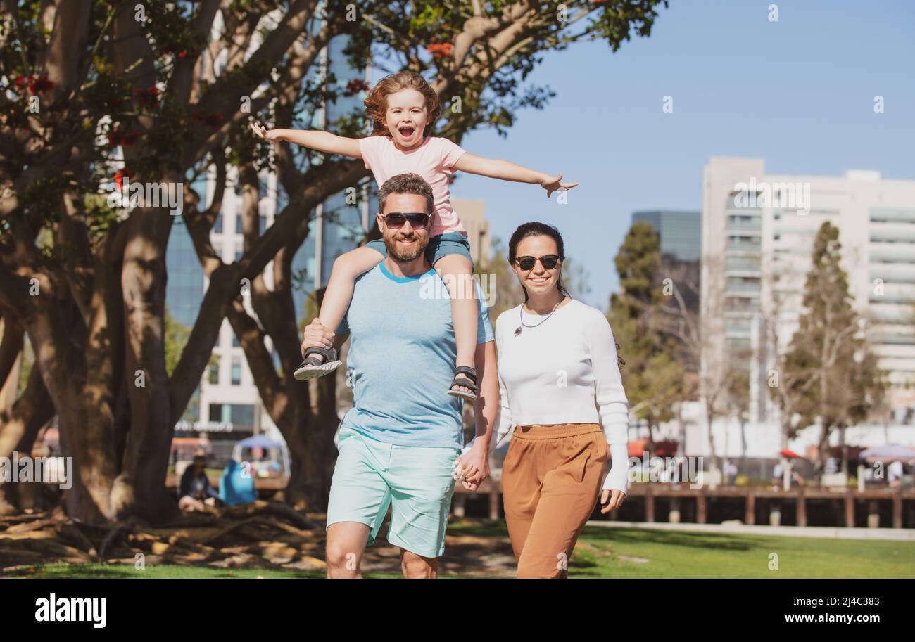 Parents with son walking in the city. Family taking a walk on street ...