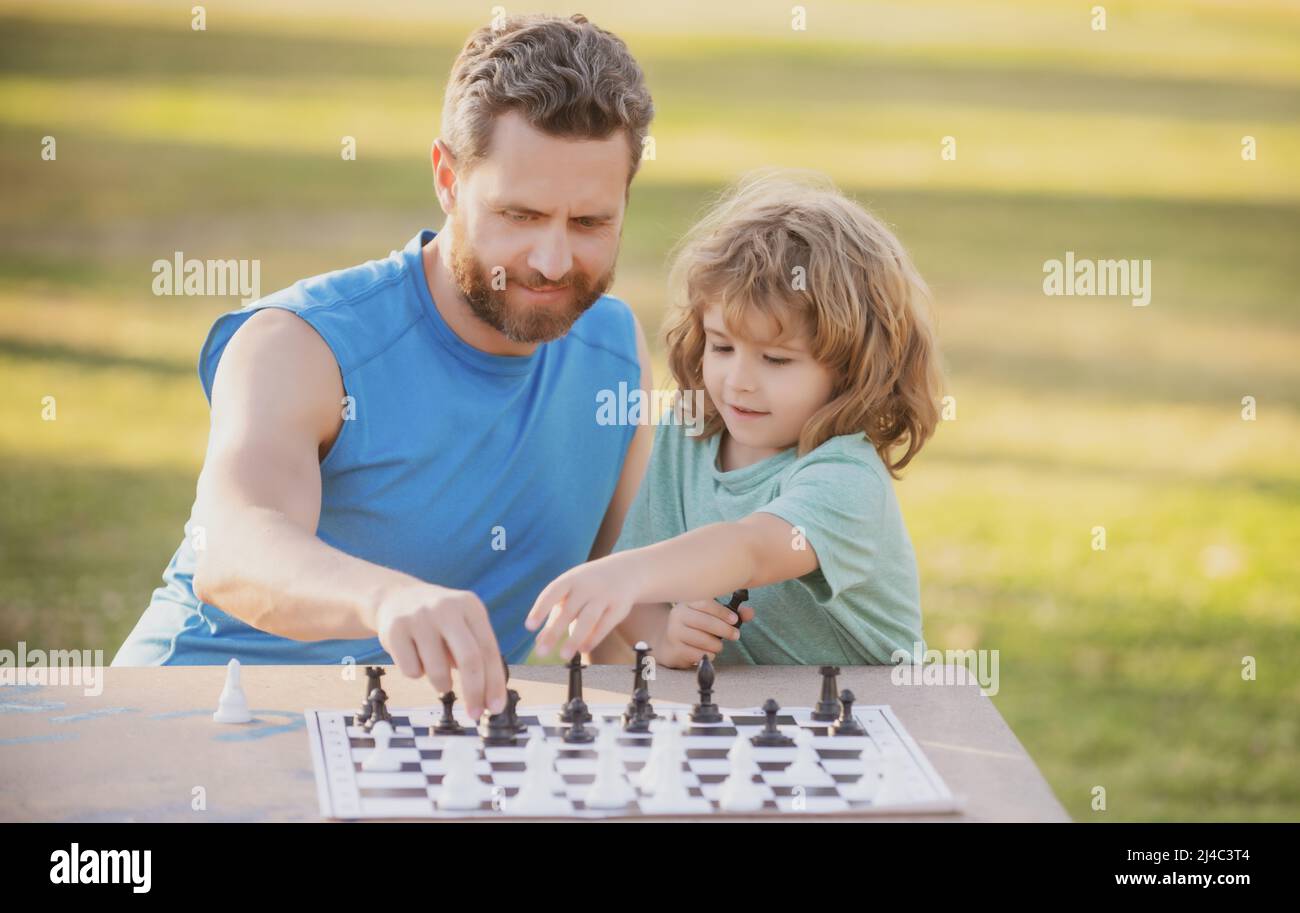Father and son playing chess spending time together outdoor. Kid play ...