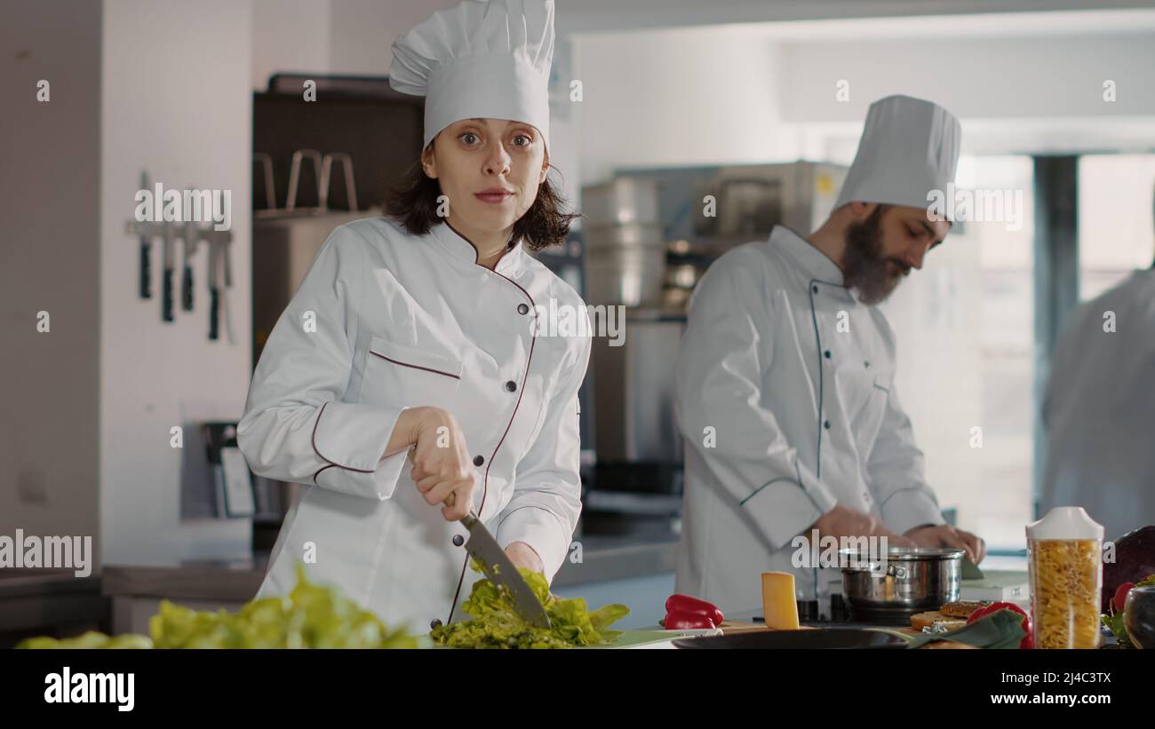 Portrait of female chef preparing celery ingredients for food dish ...