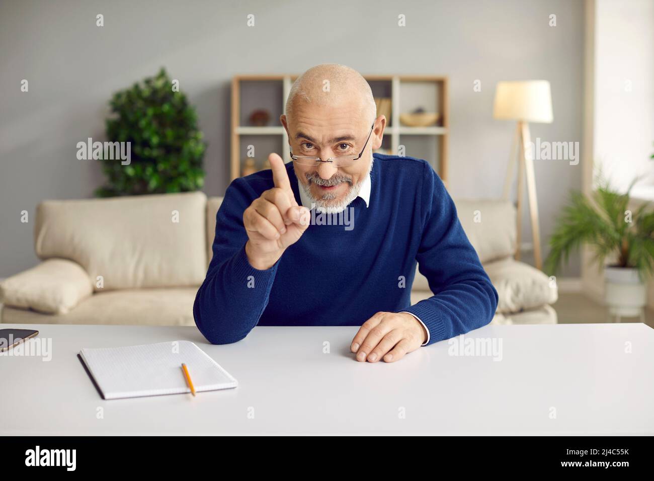 Smiling old businessman point at screen talk with viewer Stock Photo ...