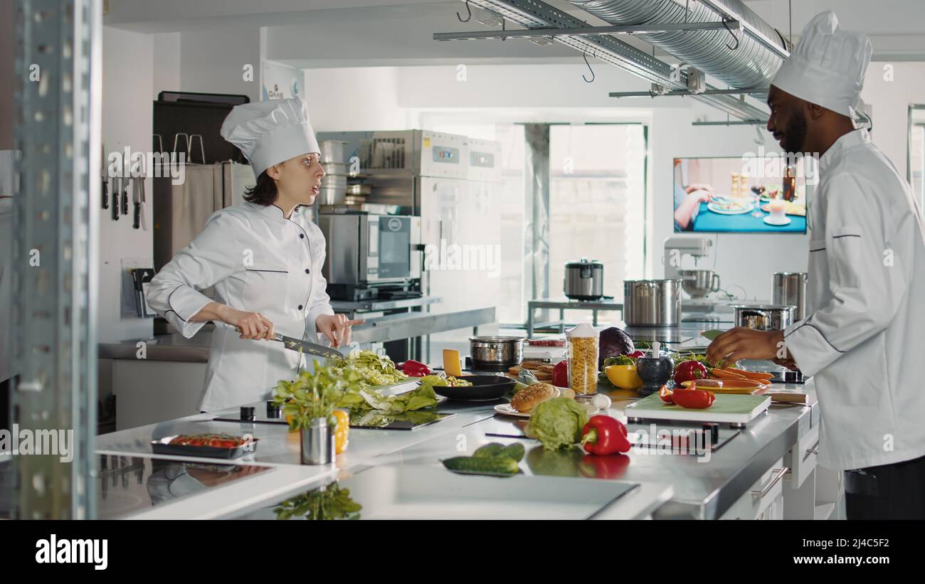Man and woman cutting fresh ingredients to make gourmet dish, doing ...