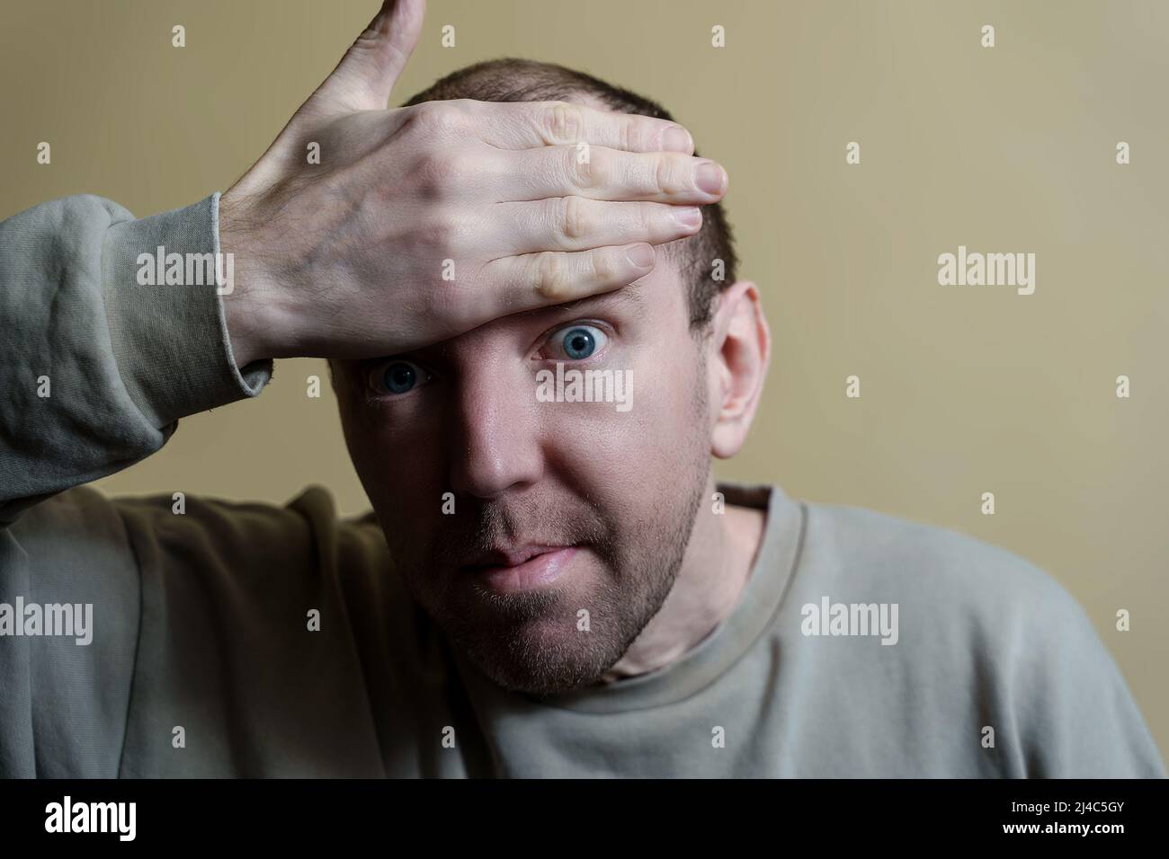 The man put his hand to his forehead. Portrait of a young man making ...