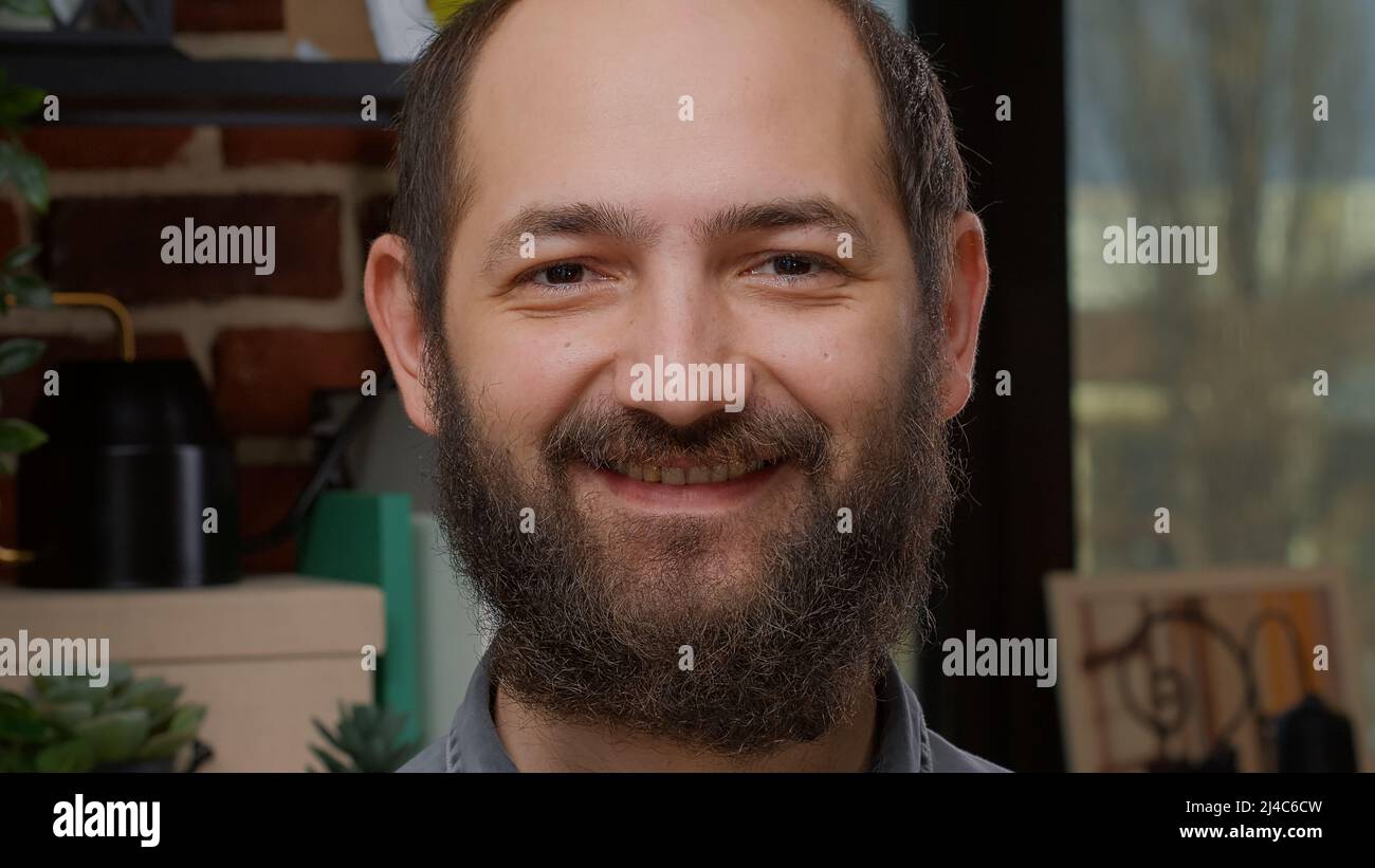 Portrait of caucasian man with unshaved beard smiling in front of ...