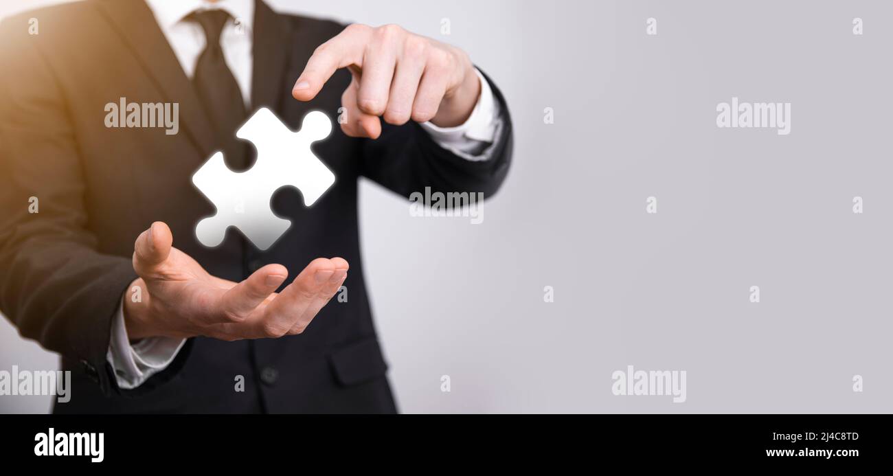 Businessman hands connecting puzzle pieces representing the merging of ... Businessman hands connecting puzzle pieces representing the merging of ...