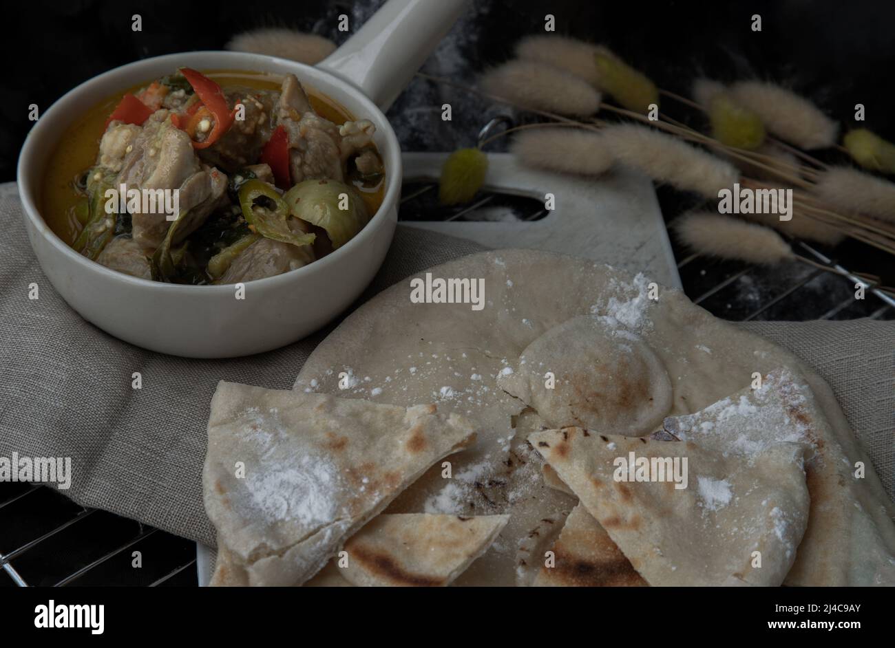 Homemade pita bread served with Green curry chicken (Kaeng khiao wan ...