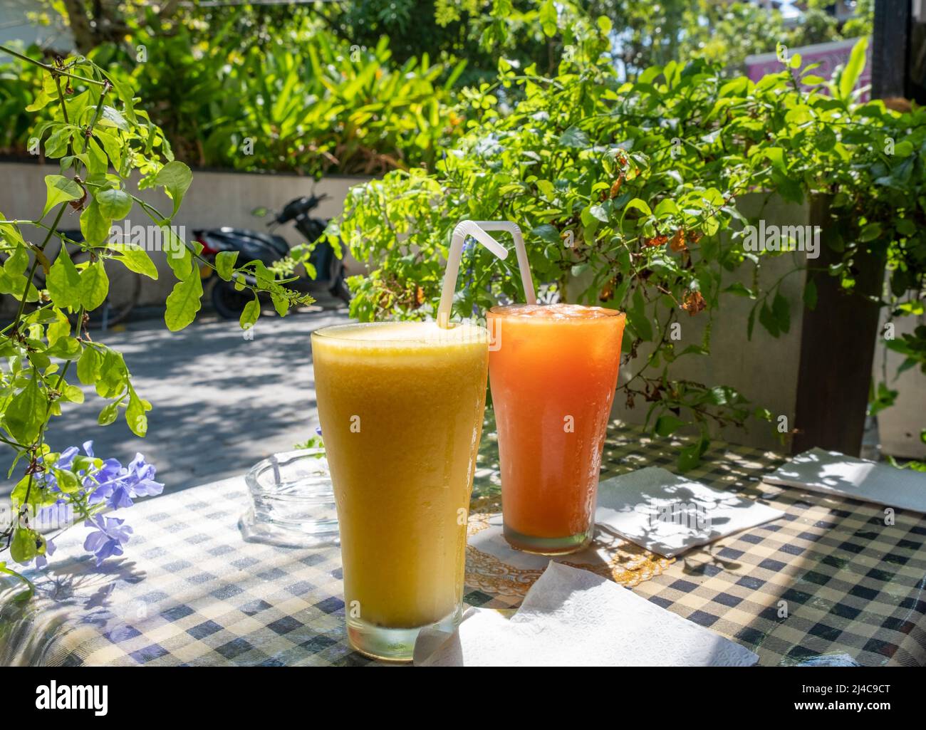 organic juices on small table with tropical view Stock Photo - Alamy