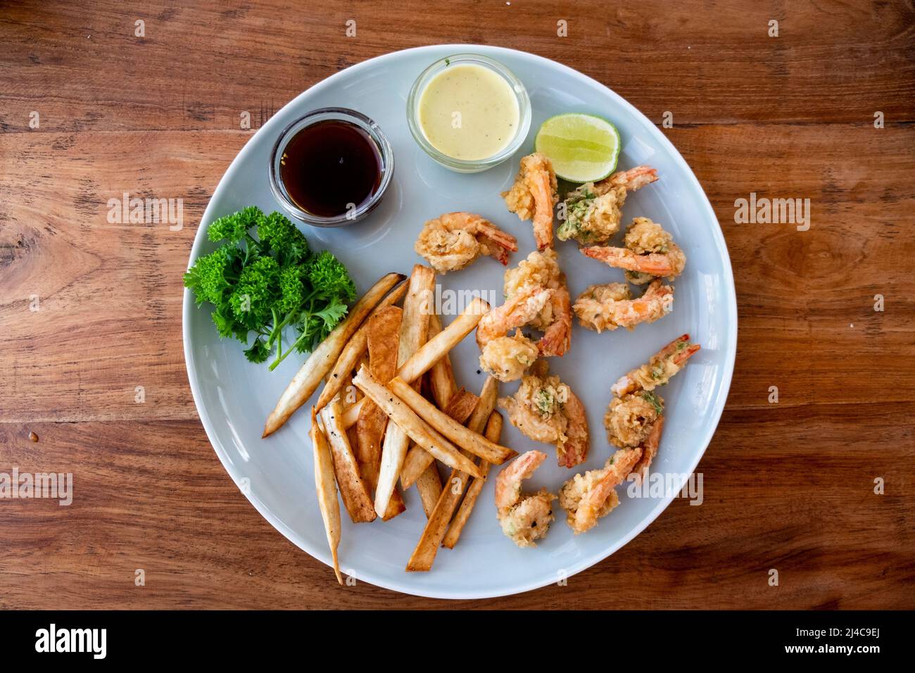 Shrimp tempura and salad of fresh vegetables close-up on a plate on a ...