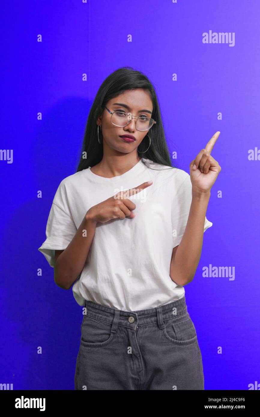 Confused young woman frowning, judging, smirk and look upset and ...