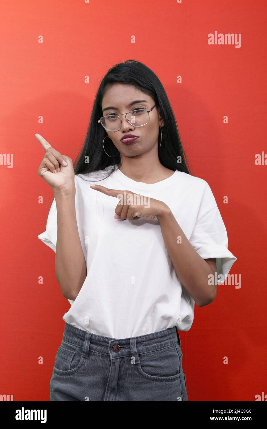 Confused young woman frowning, judging, smirk and look upset and ...