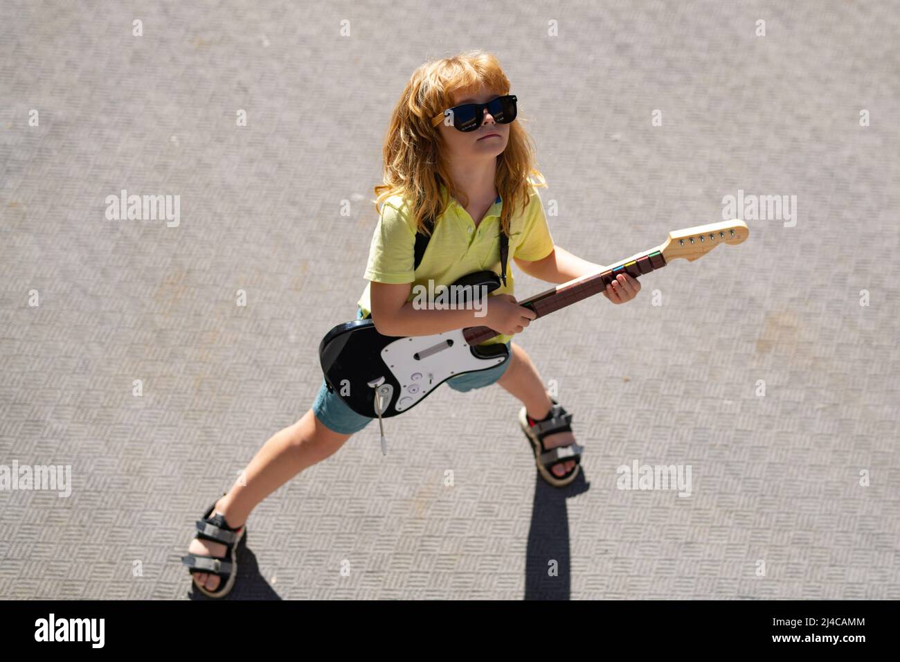 Little boy playing guitar outdoor. Music for children. Funny little ...