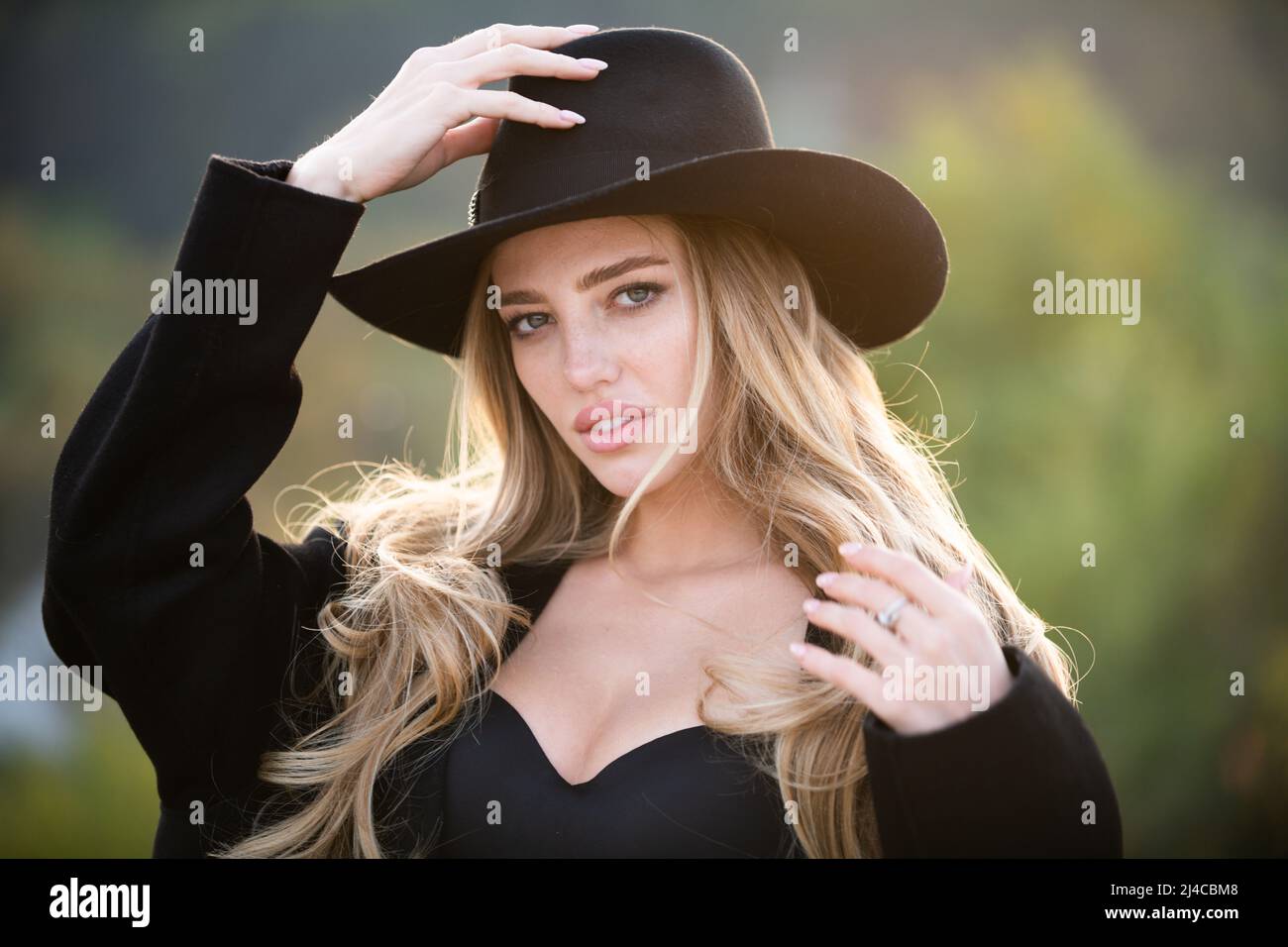 Portrait of beautiful young woman in wide broad brim hat. Outdoor ...