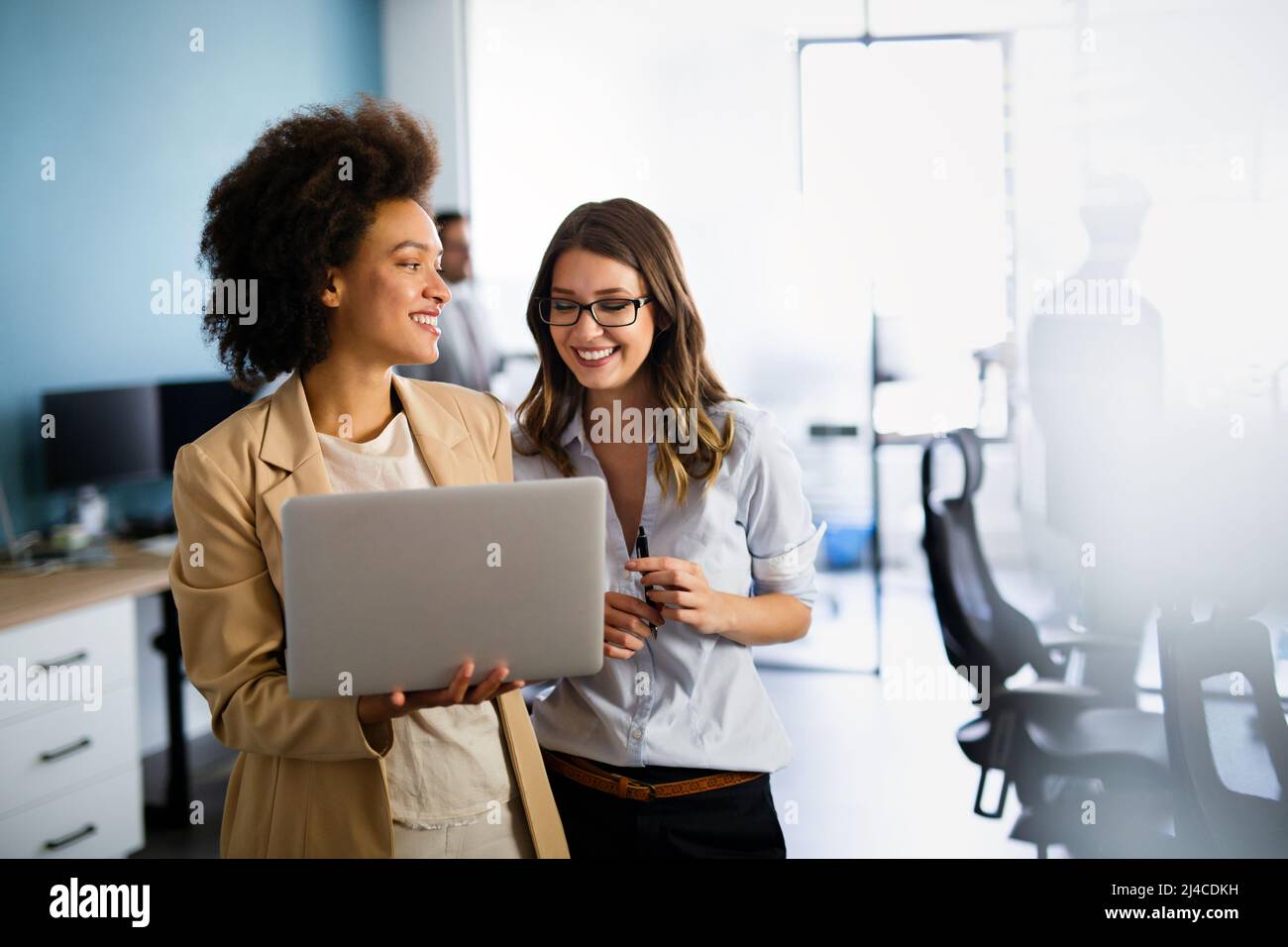 Happy smiling business women working together online on a laptop in ...