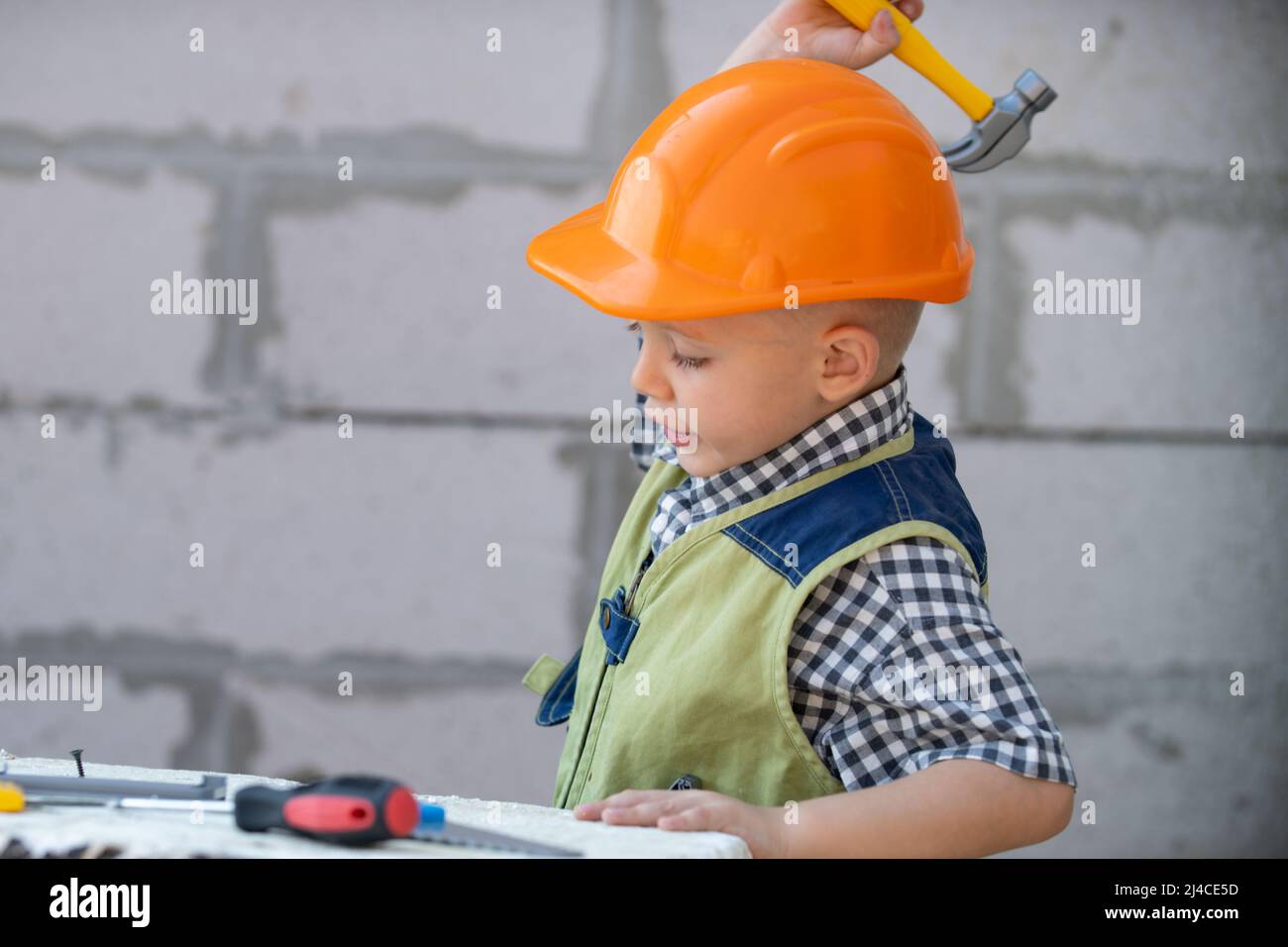 Portrait of little builder in hardhats with instruments for renovation ...