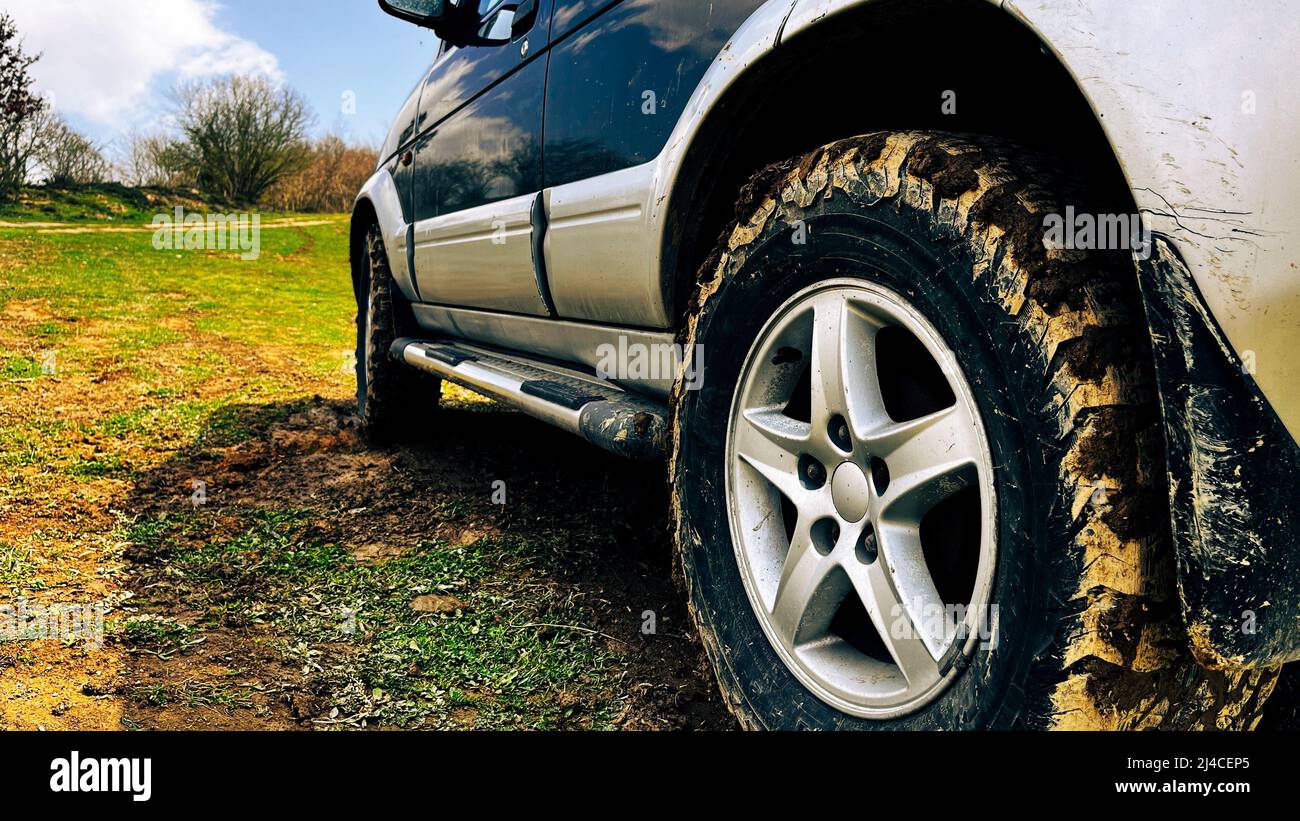 Muddy wheel of off-road vehicle. All-terrain vehicle parked on dirt ...
