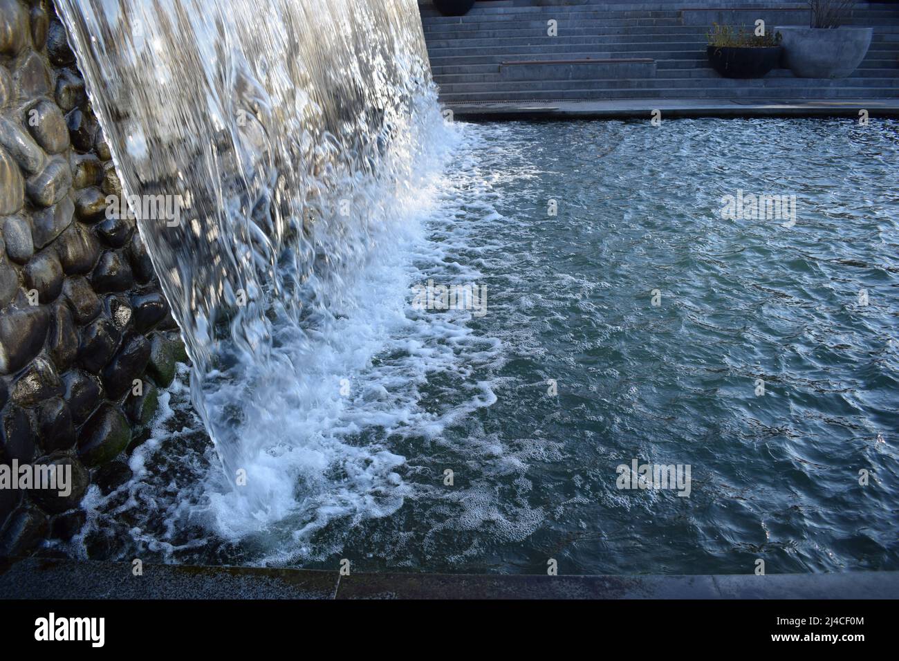 A waterfall flowing at park. A waterfall of a fountain in a garden ...