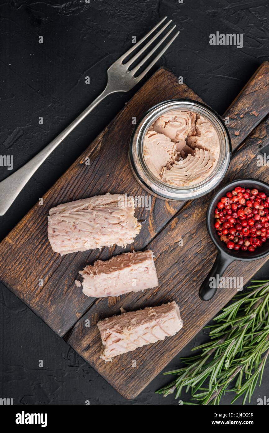 Canned tuna fillet meat in olive oil, on black background, top view ...