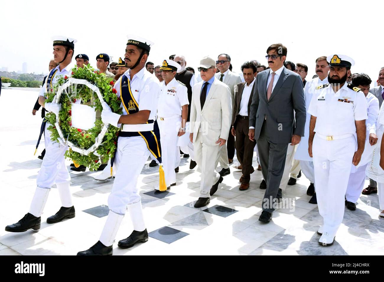 Pakistan’s Prime Minister Shehbaz Sharif (center with cap) lays floral ...