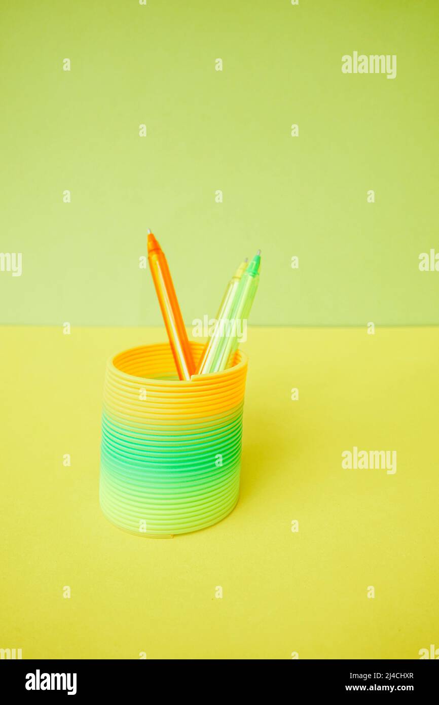 Colorful pens inside a colorful slinky toy Stock Photo - Alamy