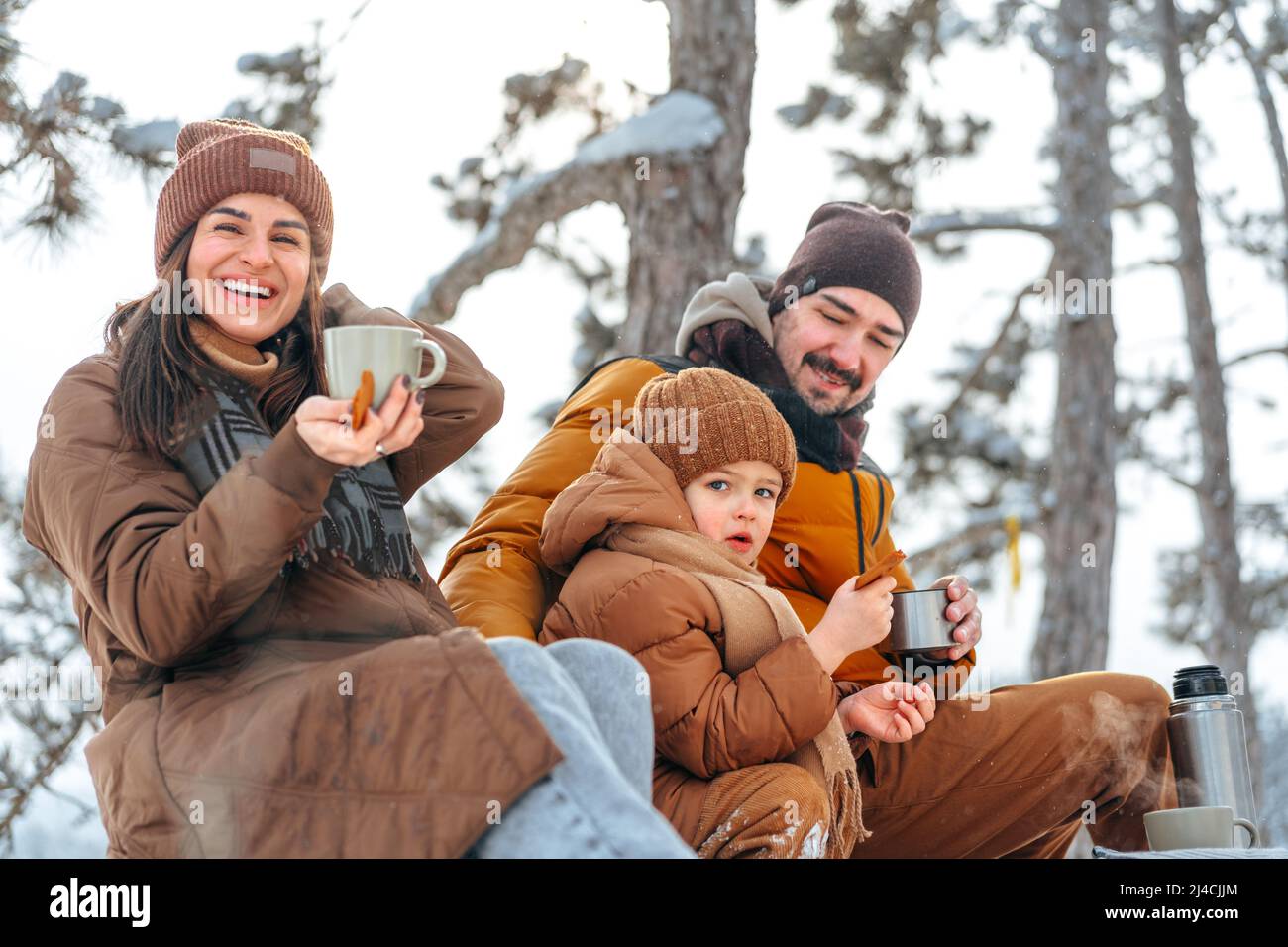 Happy family with cups of hot tea spending time together in winter ...