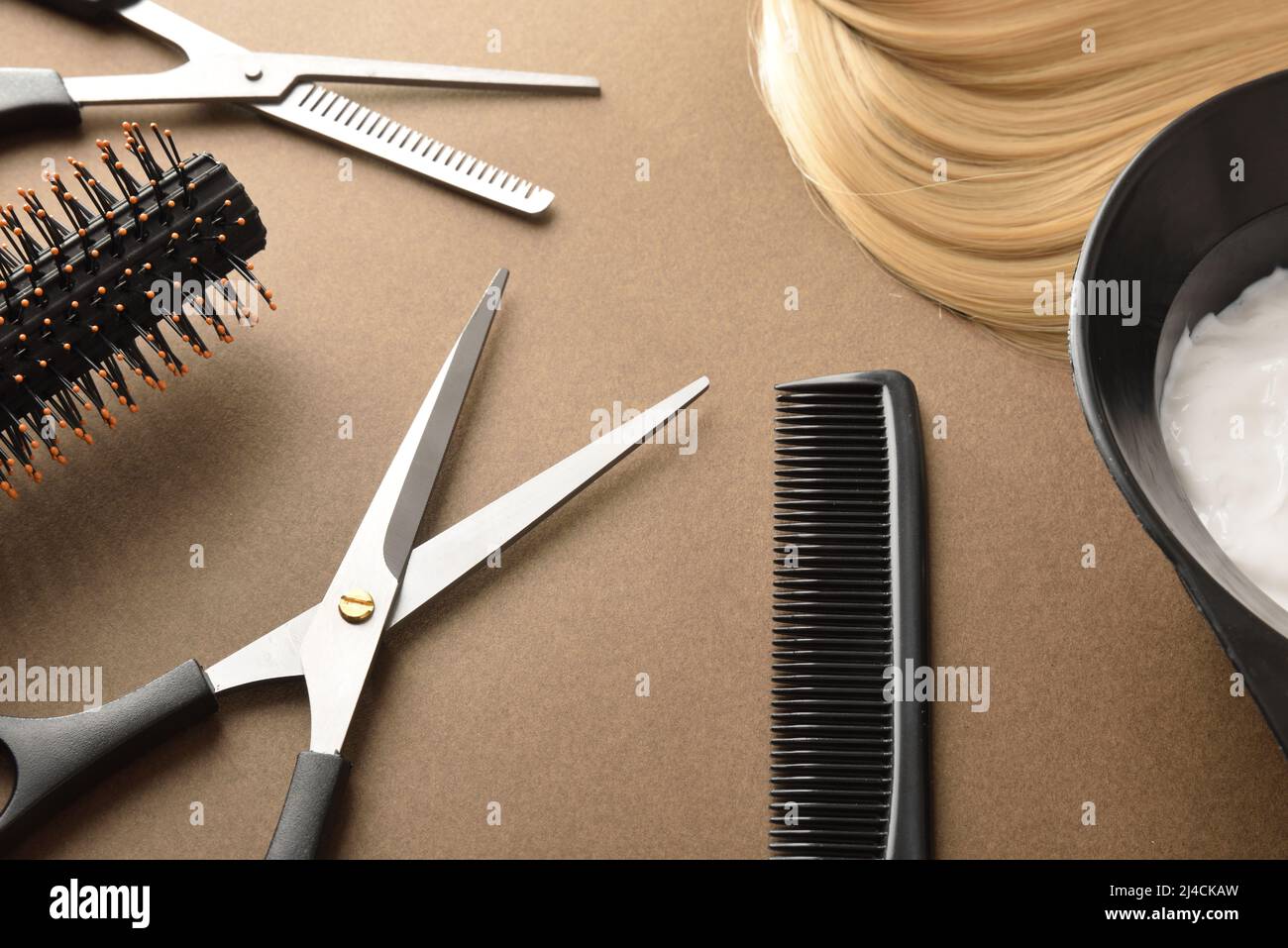 Detail of hairdressing tools for cutting and dyeing hair on brown table ...