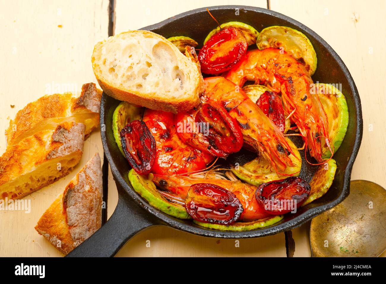 Roasted shrimps on cast iron skillet with zucchini and tomatoes Stock ...