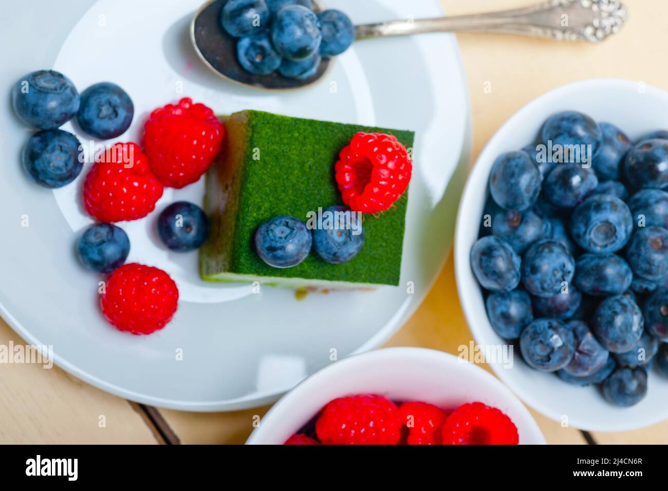 Green tea matcha mousse cake with raspberries and blueberries on top ...